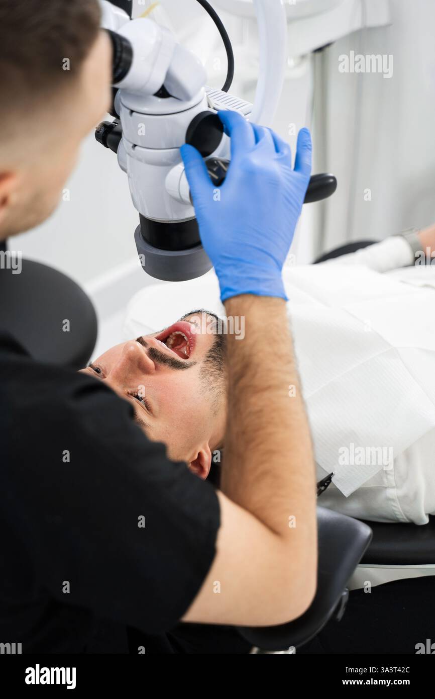 Dentist is looking on teeth condition by surgical digital microscope in ...