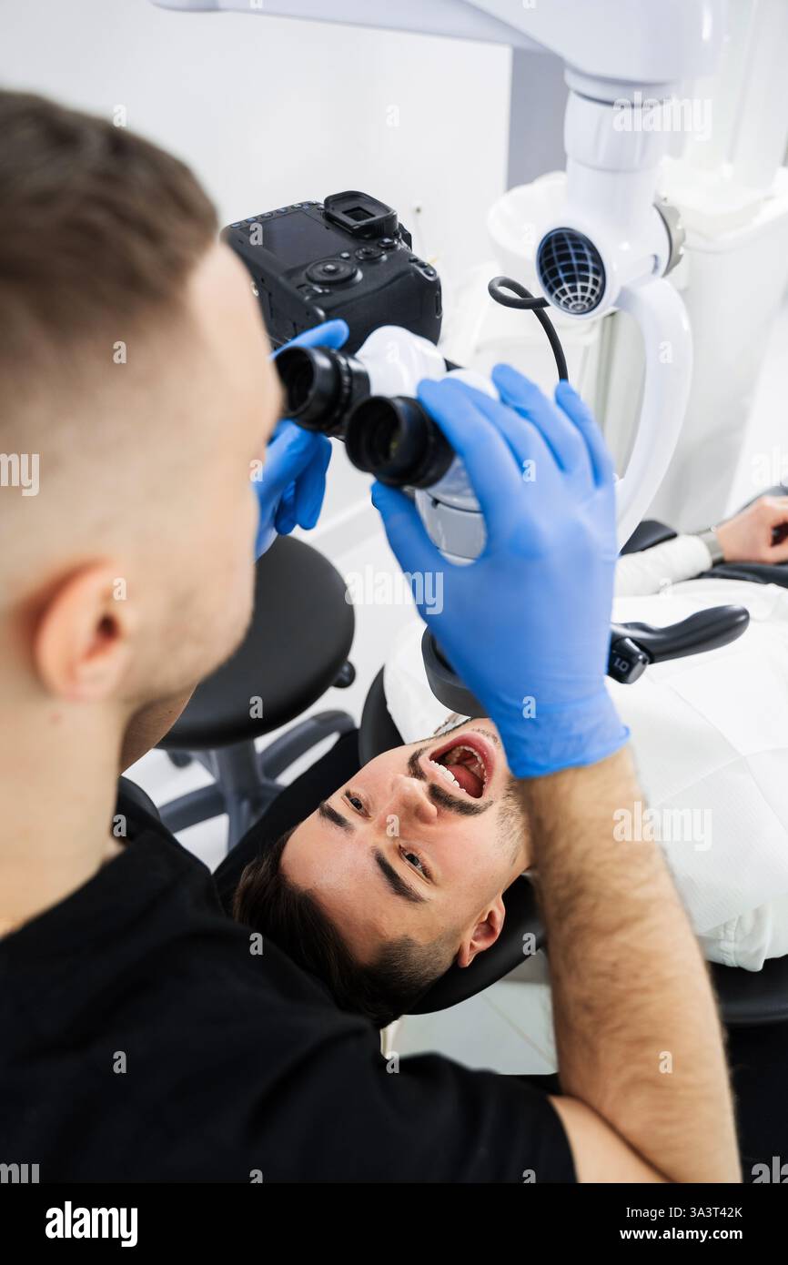 Dentist is looking on teeth condition by surgical digital microscope in ...