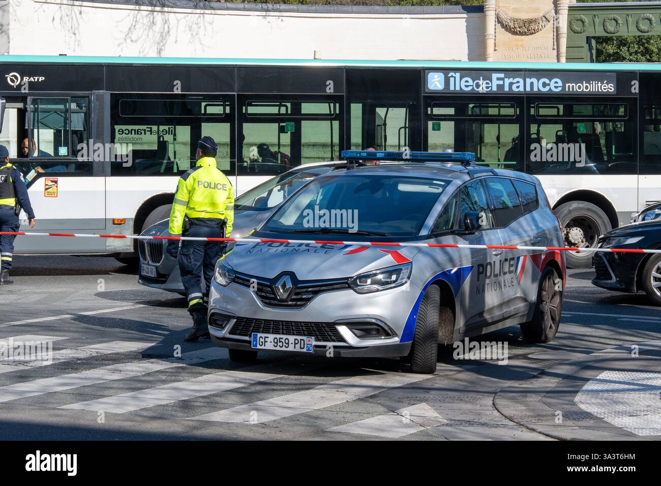 Police officers manage a traffic incident near public transport in a ...