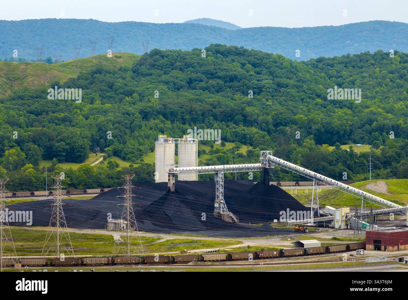 Coal-fired power plant producing electricity. Large pile of coal fossil ...