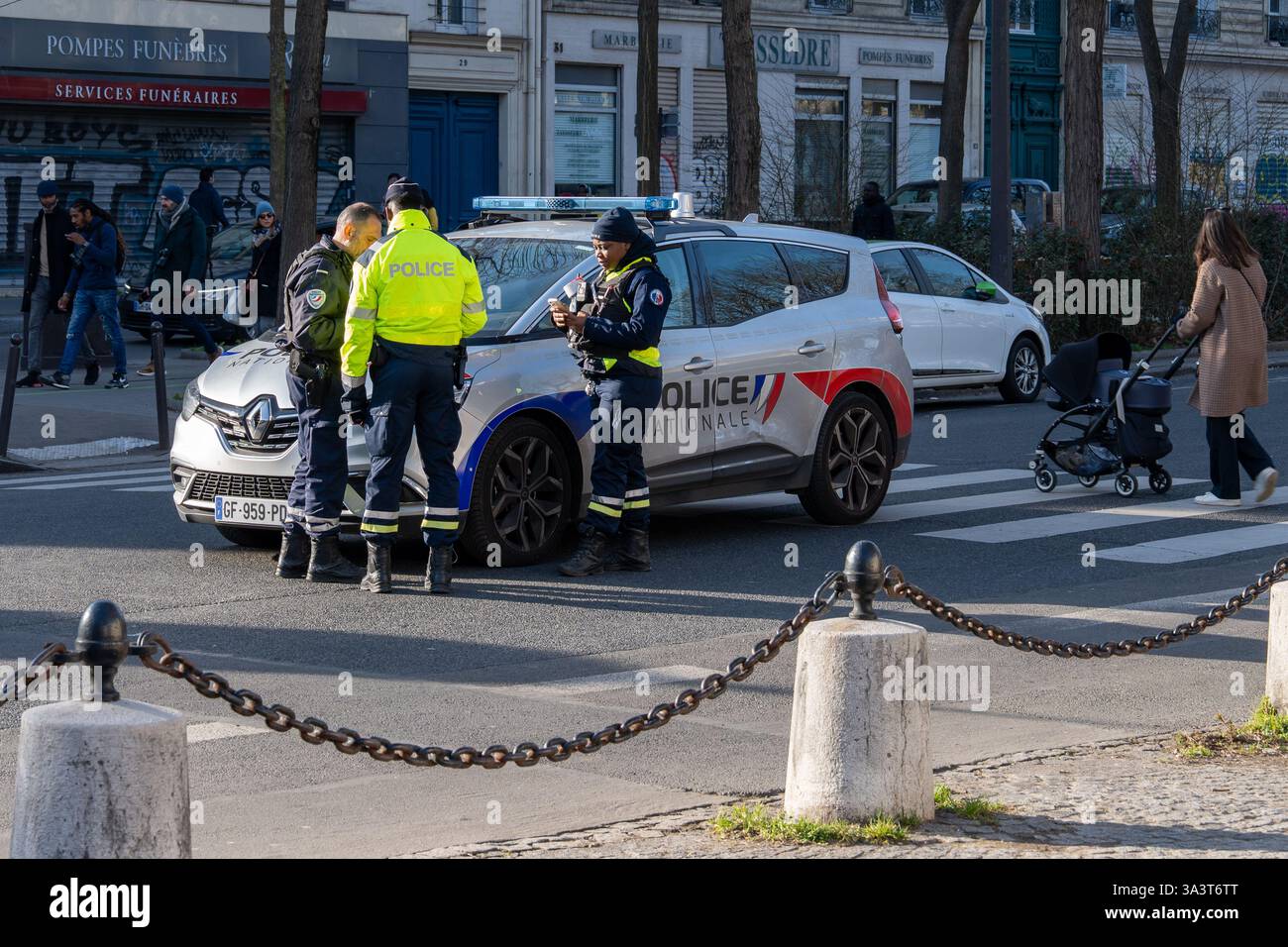 Police engaging with pedestrians on a busy street while patrolling the ...