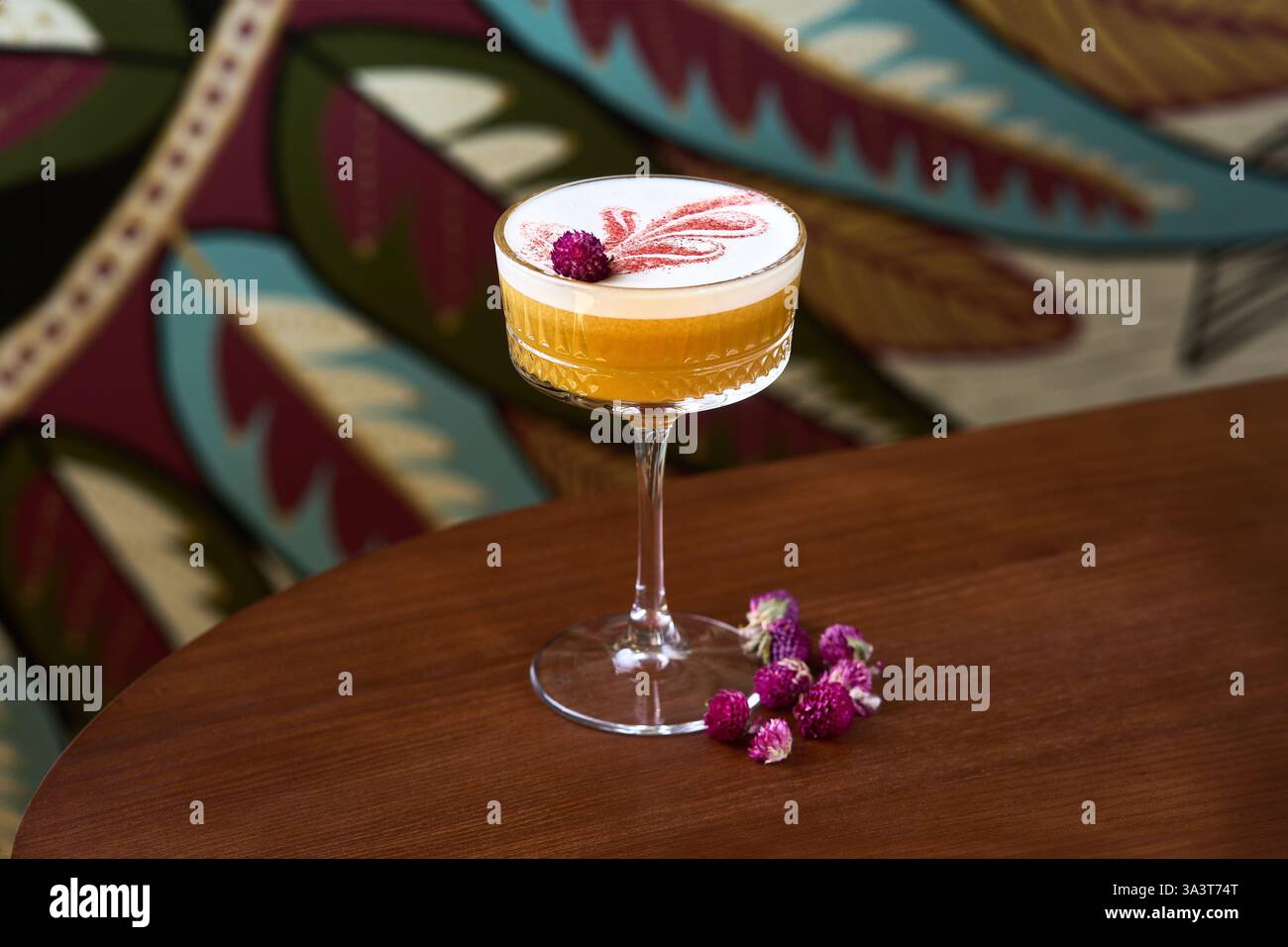 A luxurious golden cocktail served in a coupe glass. The drink is ...