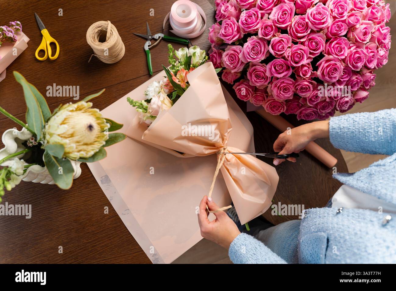 Creating a bouquet of mixed flowers by florist in floristry salon ...