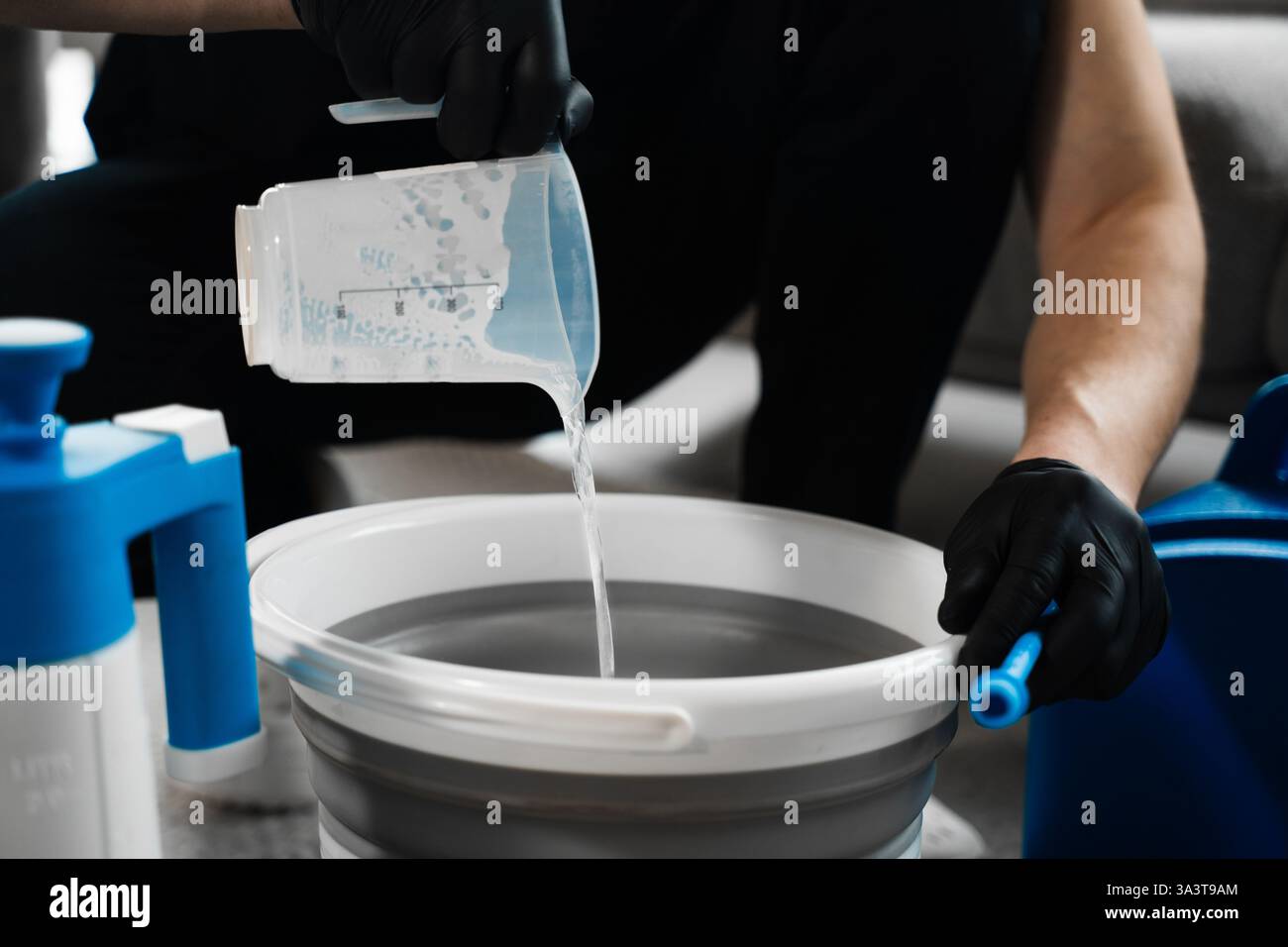 Pouring oxygen bleach mixture in the bucket for cleaning living room ...