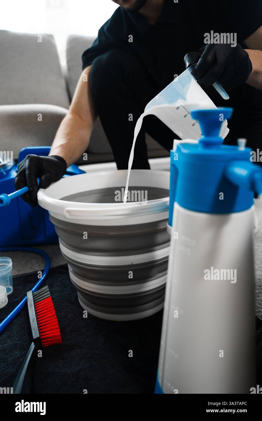 Pouring oxygen bleach mixture in the bucket for cleaning living room ...