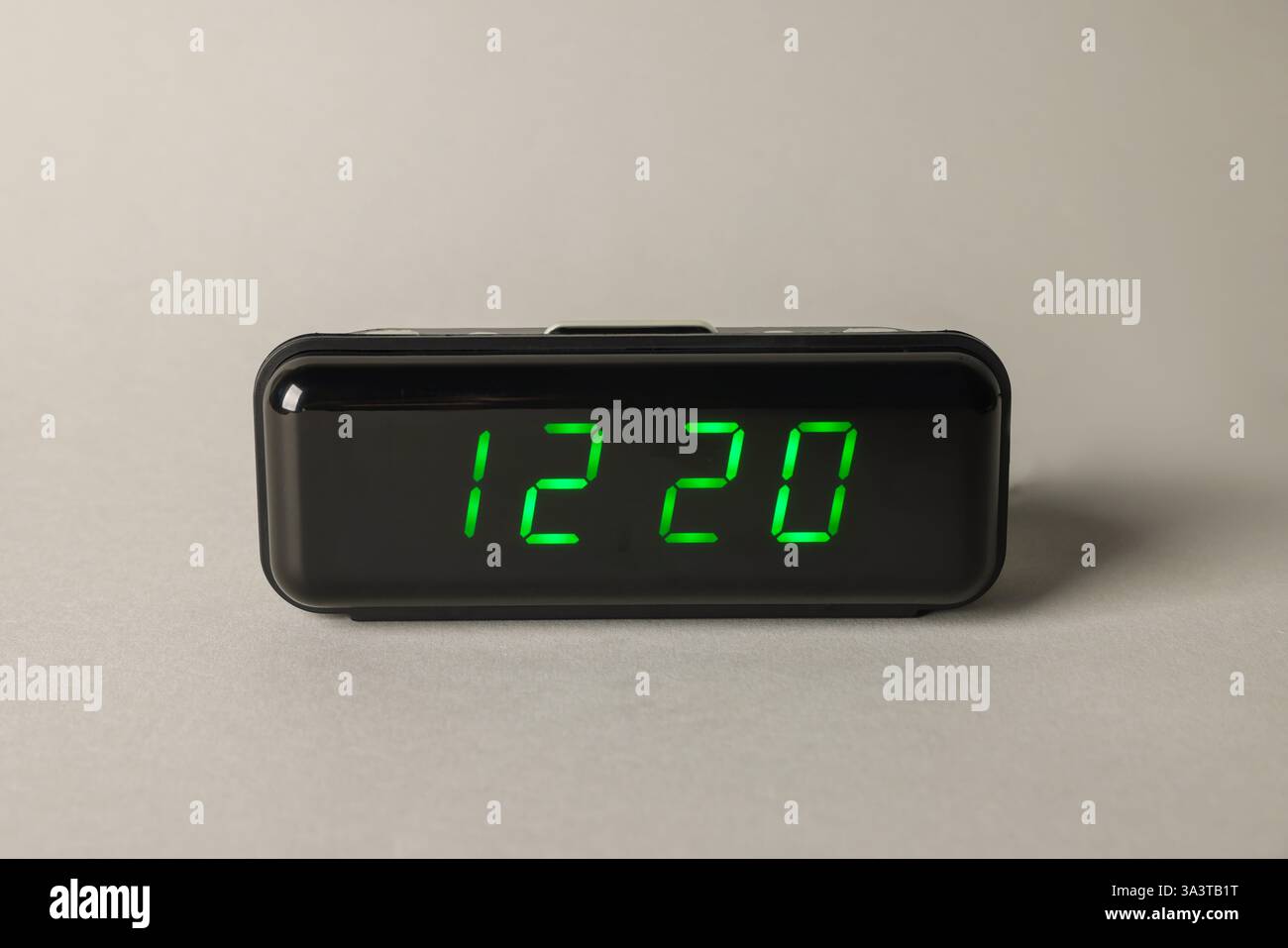 Digital alarm clock showing 12:20 o'clock on grey background Stock ...