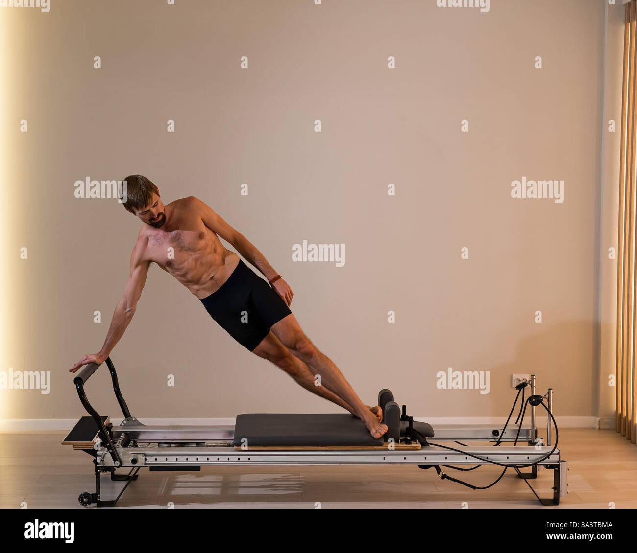 A man doing Pilates on a reformer Stock Photo - Alamy