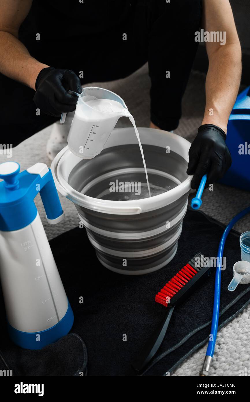 Pouring oxygen bleach mixture in the bucket for cleaning living room ...