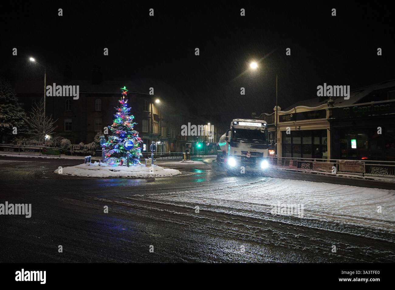 A Christmas tree on a mini-roundabout covered in overnight snow in the ...