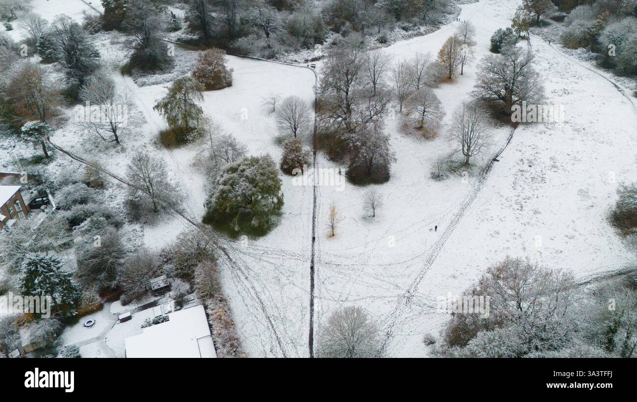 People walk through a snow-covered Priory Park after overnight snowfall ...