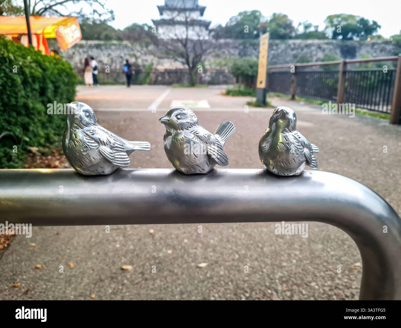 Small metal birds on a railing, art at the palace garden in Osaka ...
