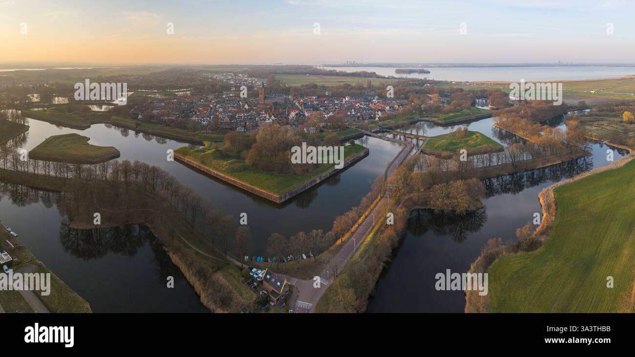Aerial view of a historic fortified town surrounded by water, green ...