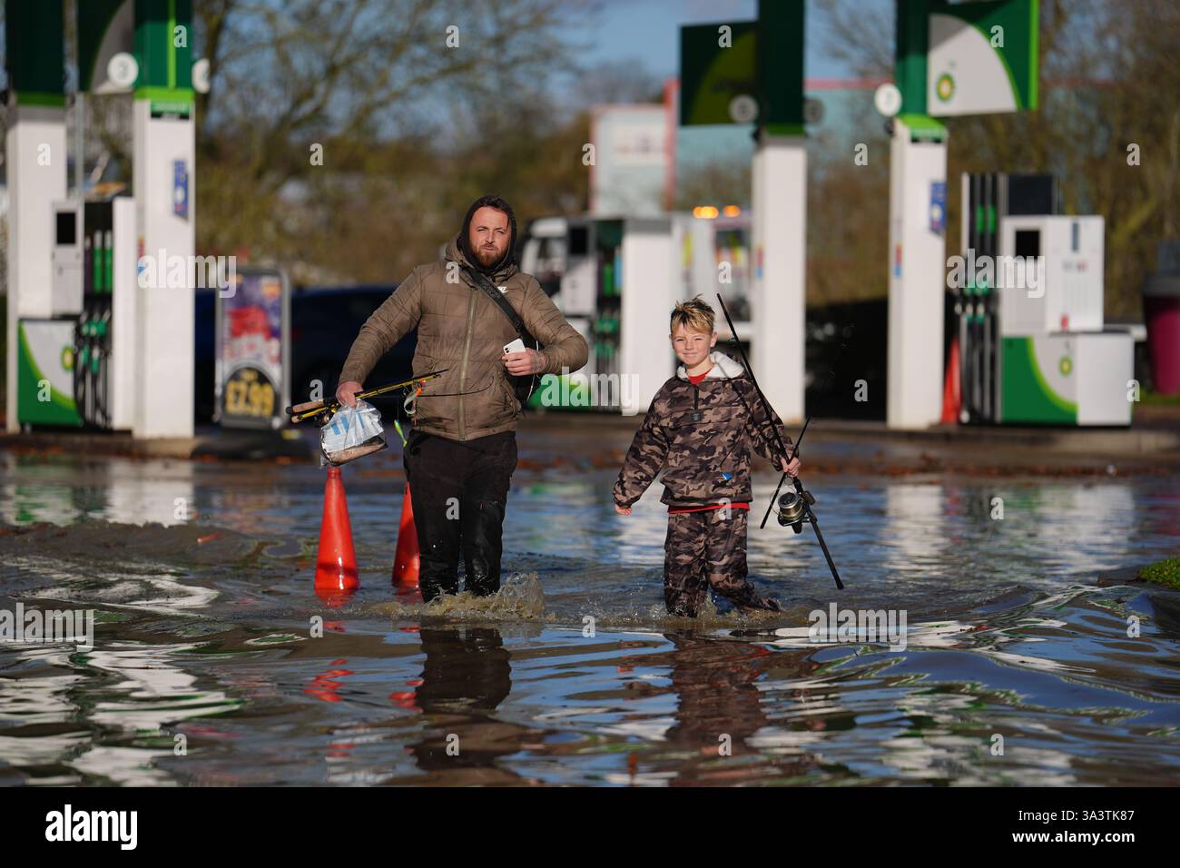 People walk through floodwater near the Billing Aquadrome in Northamptonshire. Storm Bert will ...