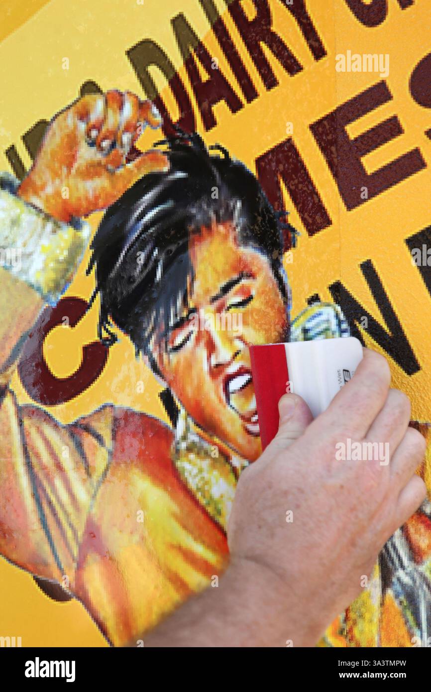 Anthony Culver, with Fast Wrapz of Tupelo, installs a mural outside of ...