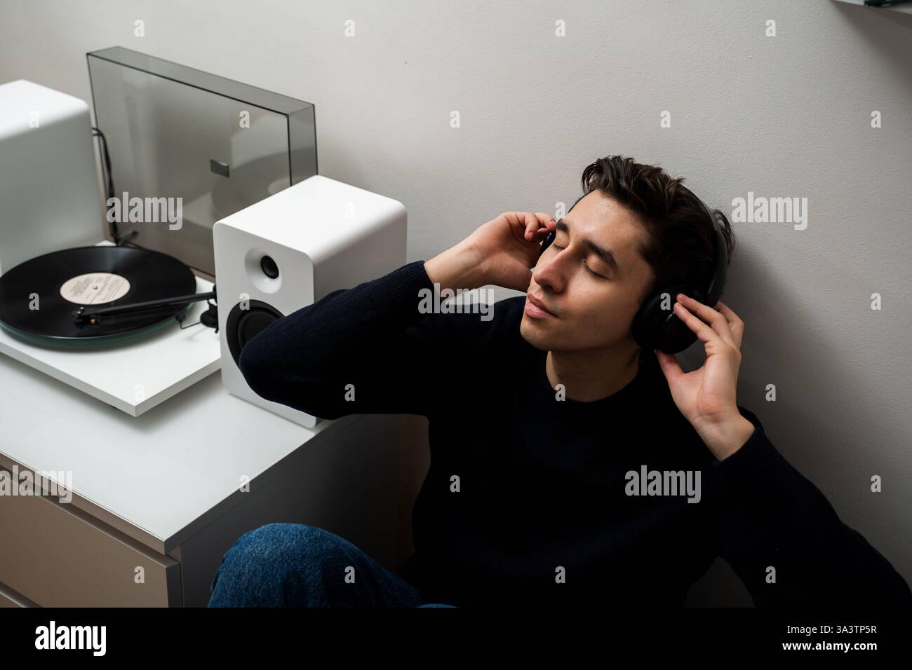 Man is relaxing with vinyl rock records from speaker system at home ...