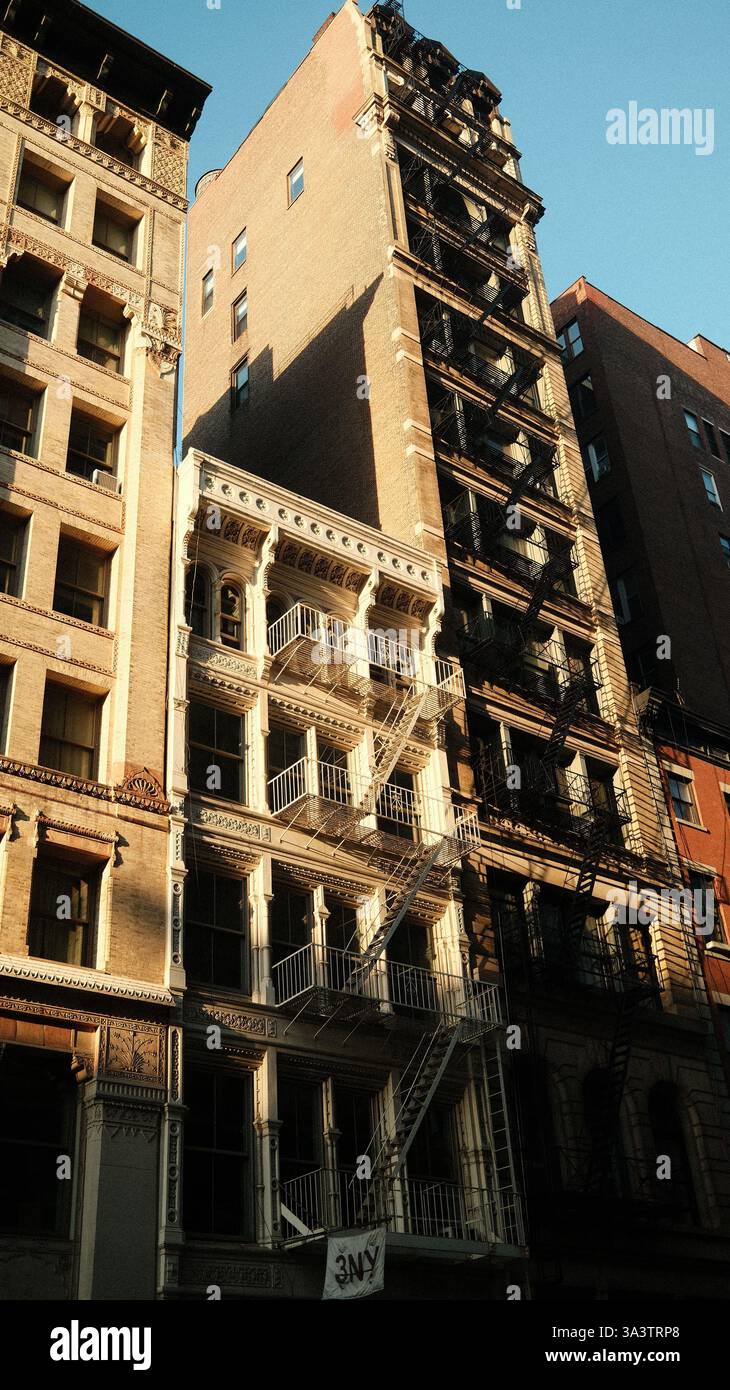 Sunlit historic buildings with intricate facades and classic fire ...