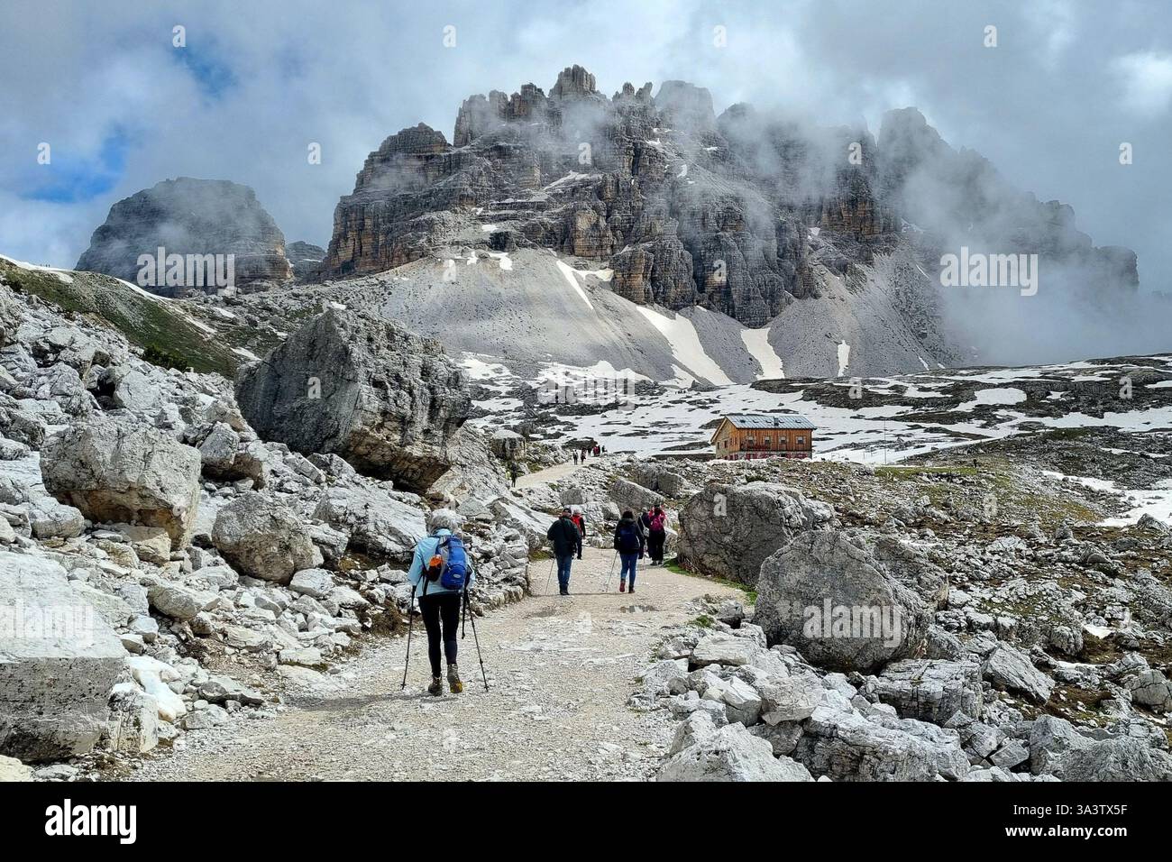 A group of hikers and unrecognized elderly female tourist with walking ...