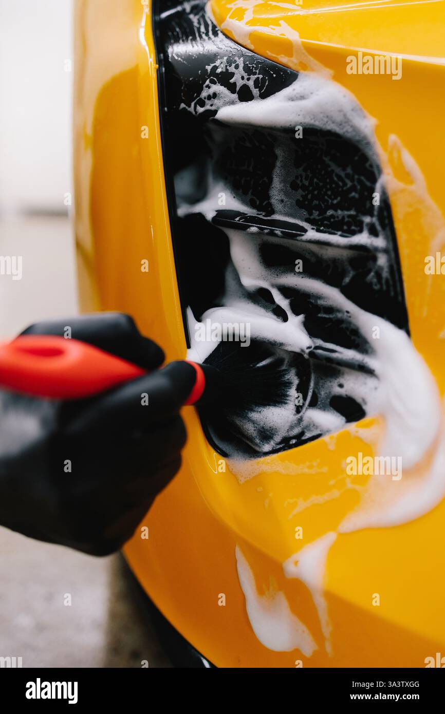 Application of detergent to brush during a professional car detailing ...
