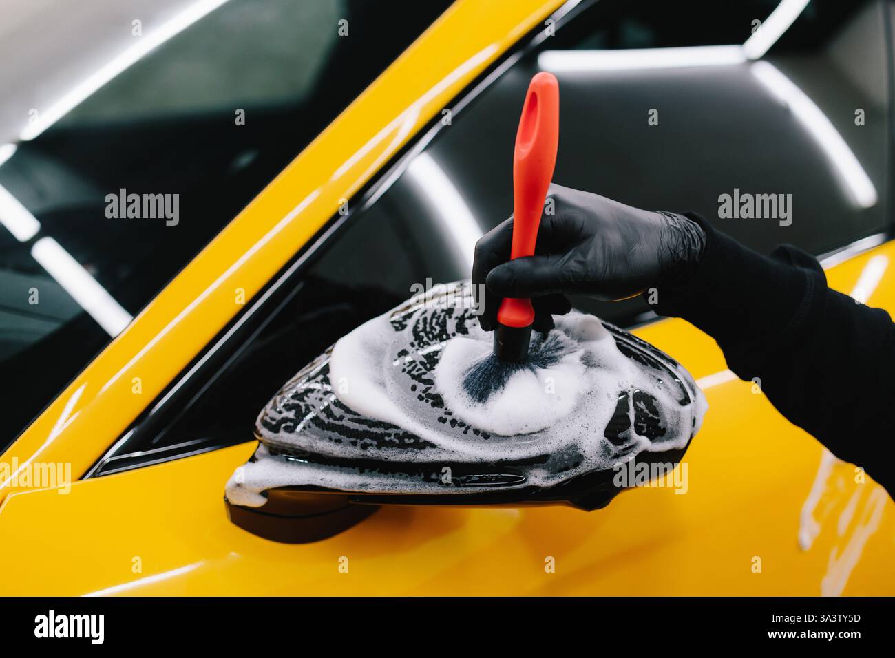Detailing procedure of brushing soap solution to the car mirror ...
