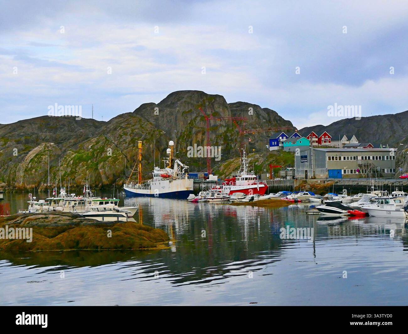 Scenic seascape with fishing boats in the port Maniitsoq and colorful ...
