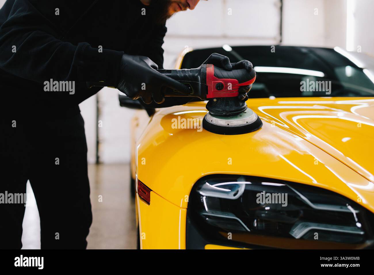 Detailing process of polishing yellow sports car hood surface using ...