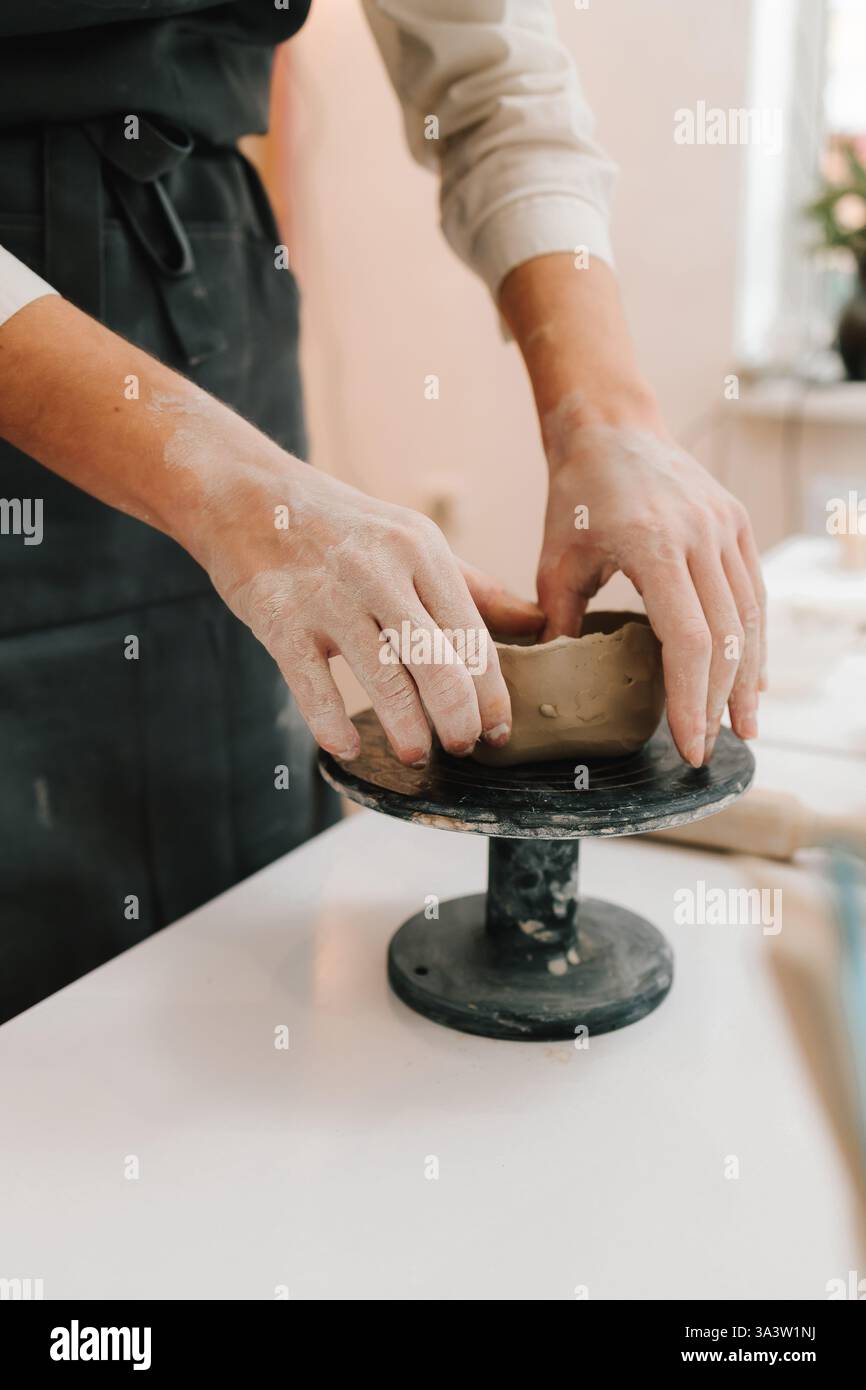 Artisan sculpts ceramic bowl using potter's wheel. Hands shaping clay ...