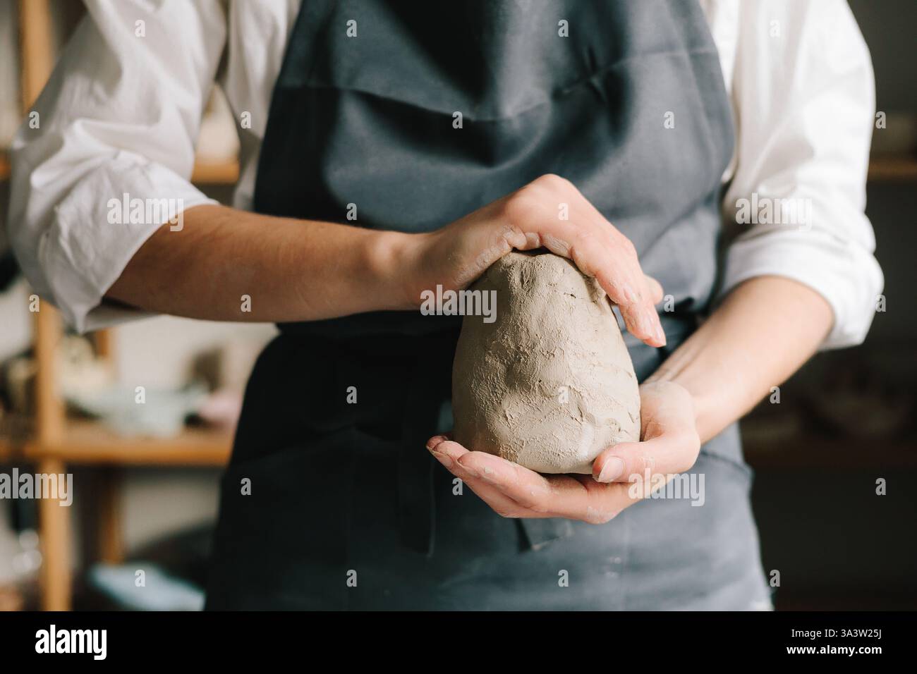 Process of creating ceramic products. Potter holds a piece of wet clay ...