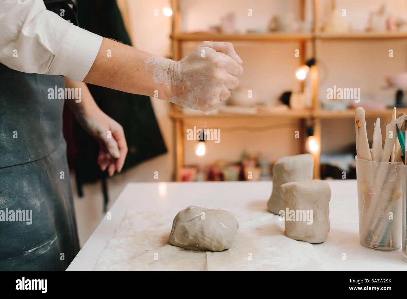 Female potter rolls piece of clay before sculpting. Preparing clay for ...