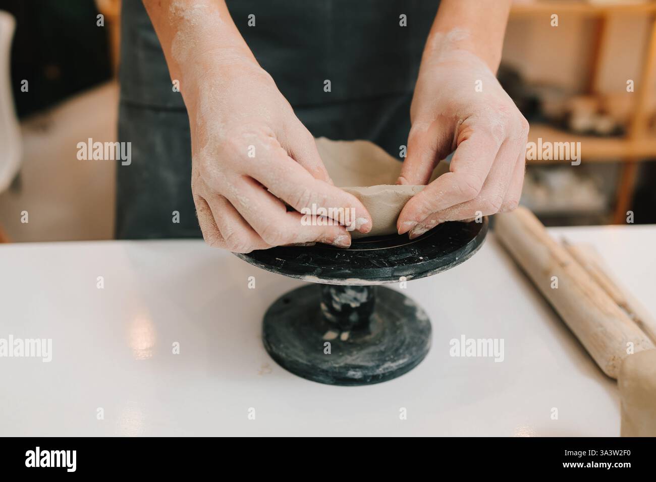 Hands shaping clay into dish in the craft studio close-up. Artisan ...
