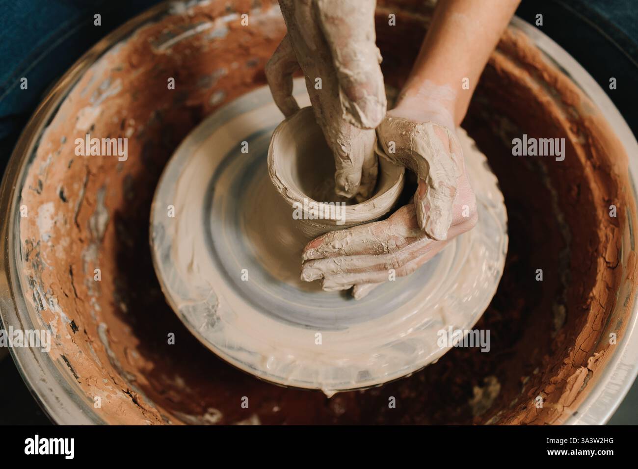 Female potter forms a clay product on a potter's wheel. Process of ...