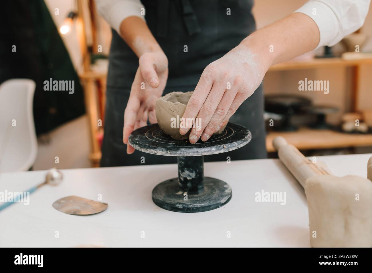 Hands shaping clay into dish in the craft studio close-up. Artisan ...