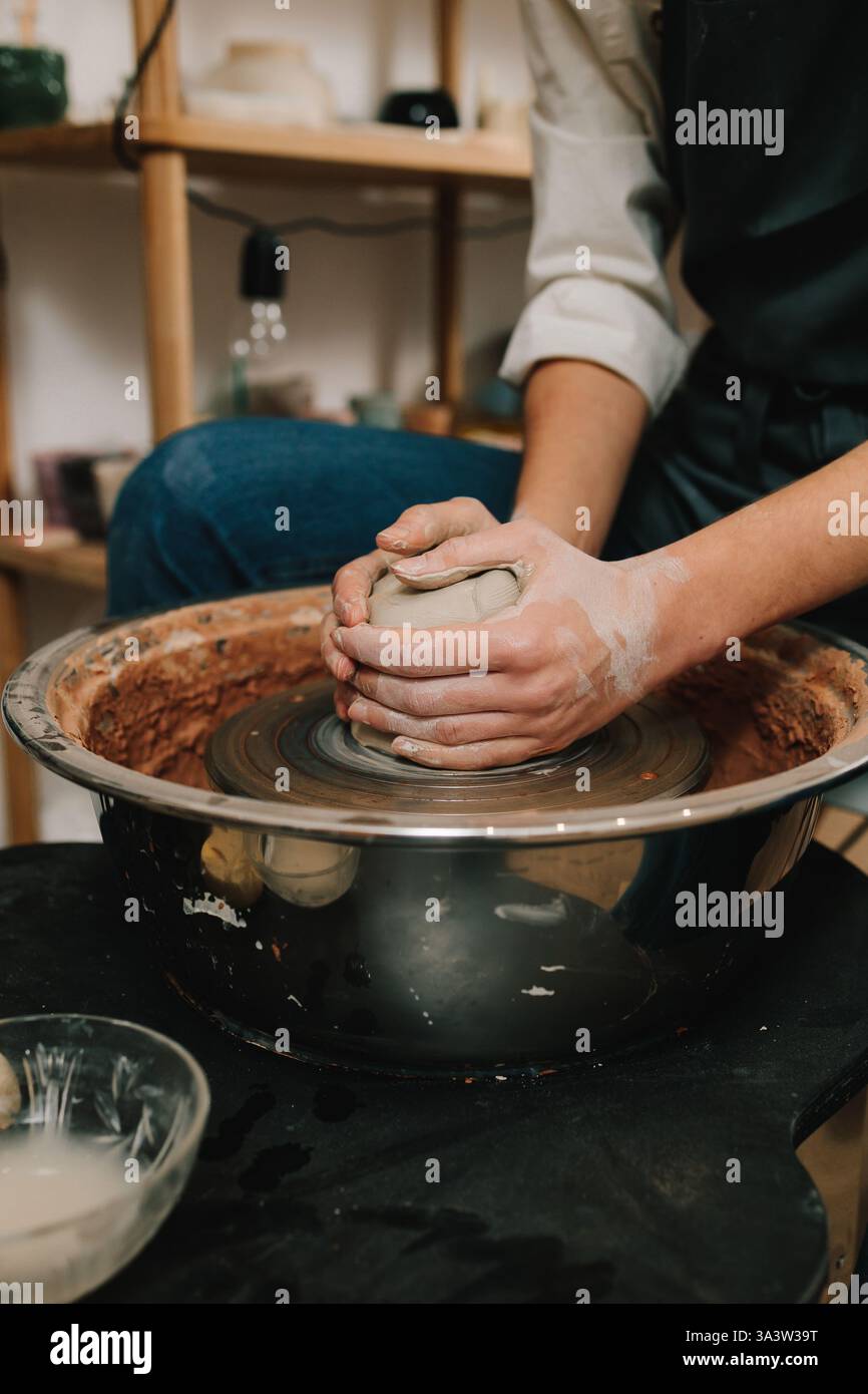 Artisan molds a piece of wet clay on the pottery wheel. Process of ...