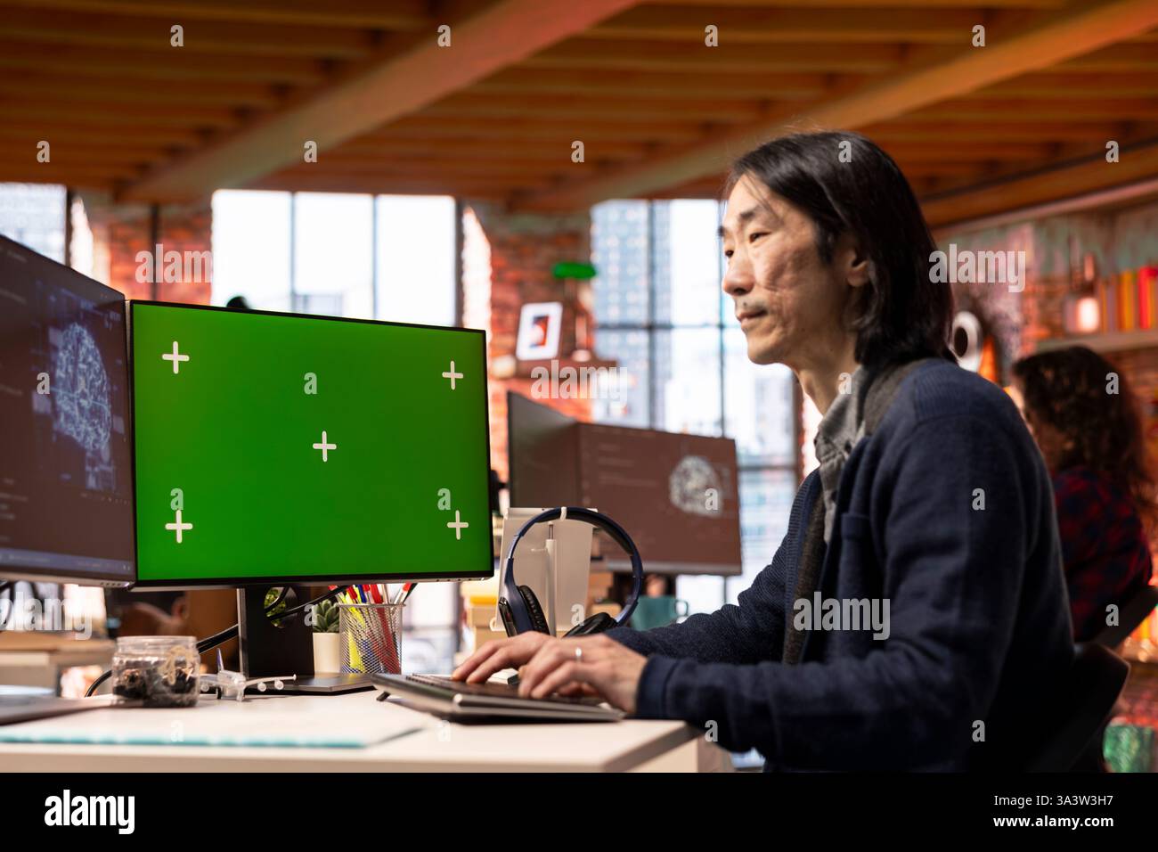 Senior programmer using chroma key computer to oversee artificial intelligence neural networks ...