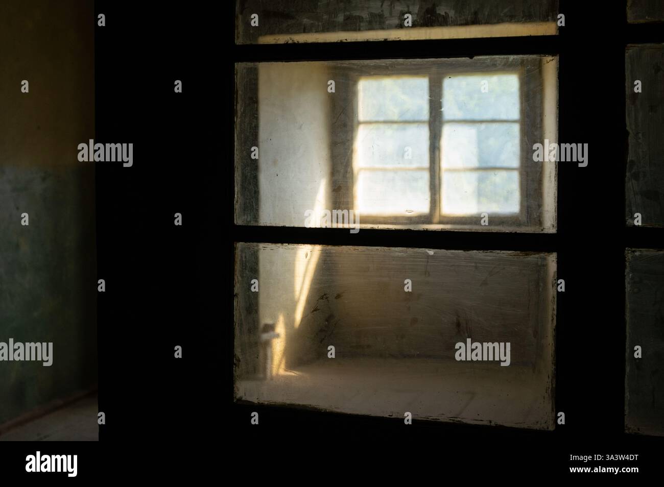 Sunlight entering a dark spooky room through filthy windows in an ...