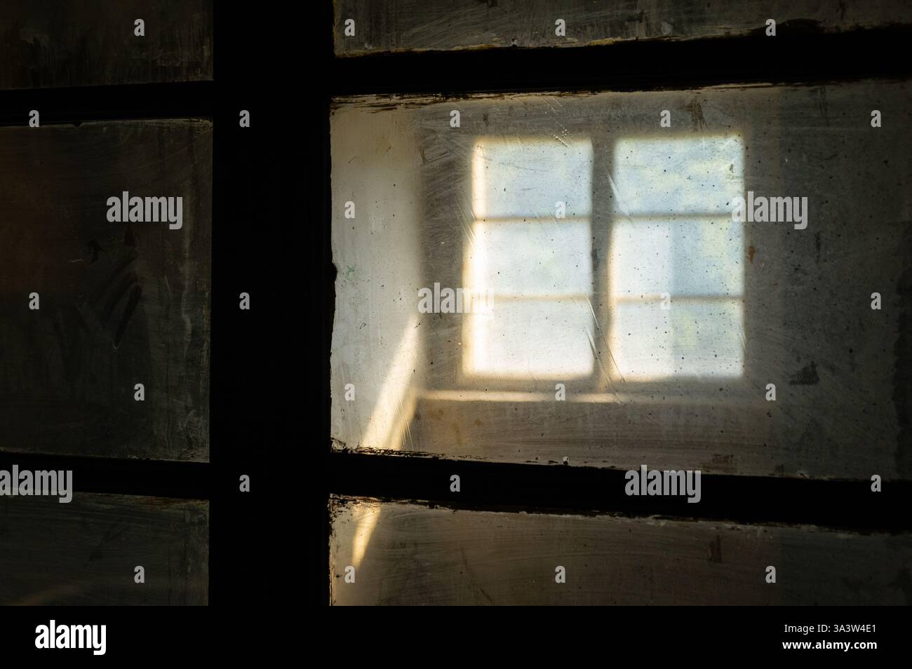 Sunlight entering a dark spooky room through filthy windows in an ...