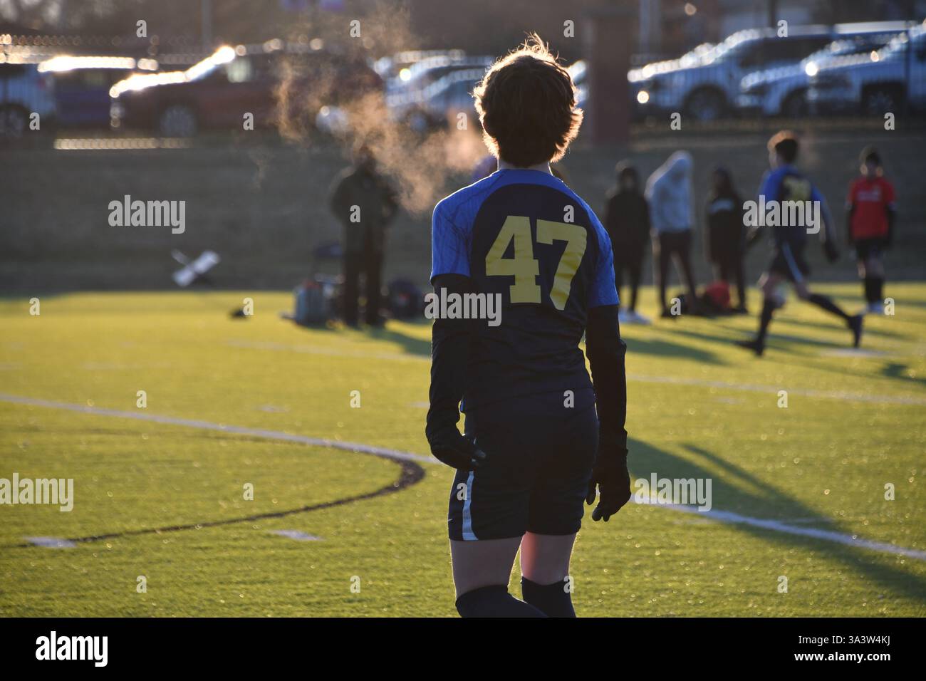 Teammates walk off the pitch following a soccer match, wearing blue and ...