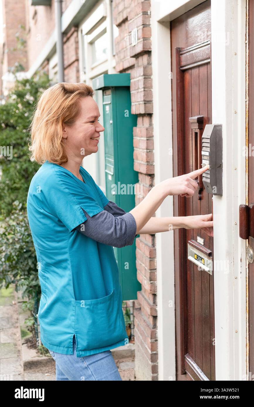 Homecare nurse ringing a client's doorbell Stock Photo - Alamy