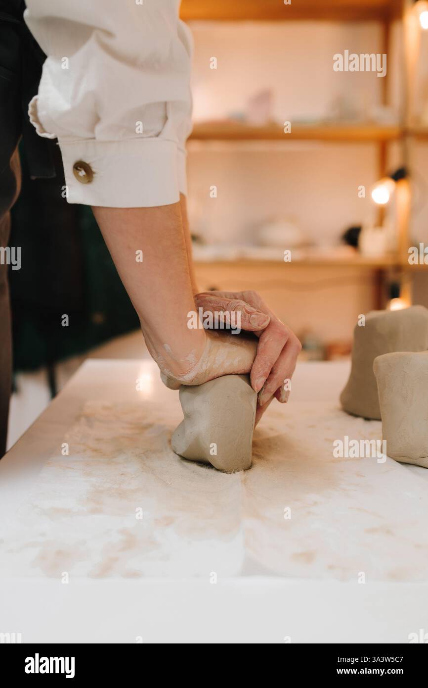 Female potter rolls piece of clay before sculpting. Preparing clay for ...