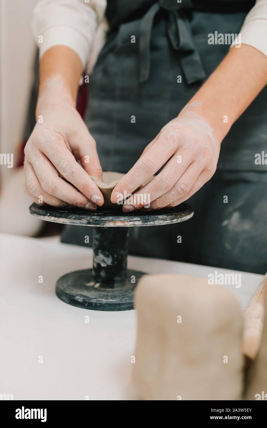 Hands shaping clay into dish in the craft studio close-up. Artisan ...