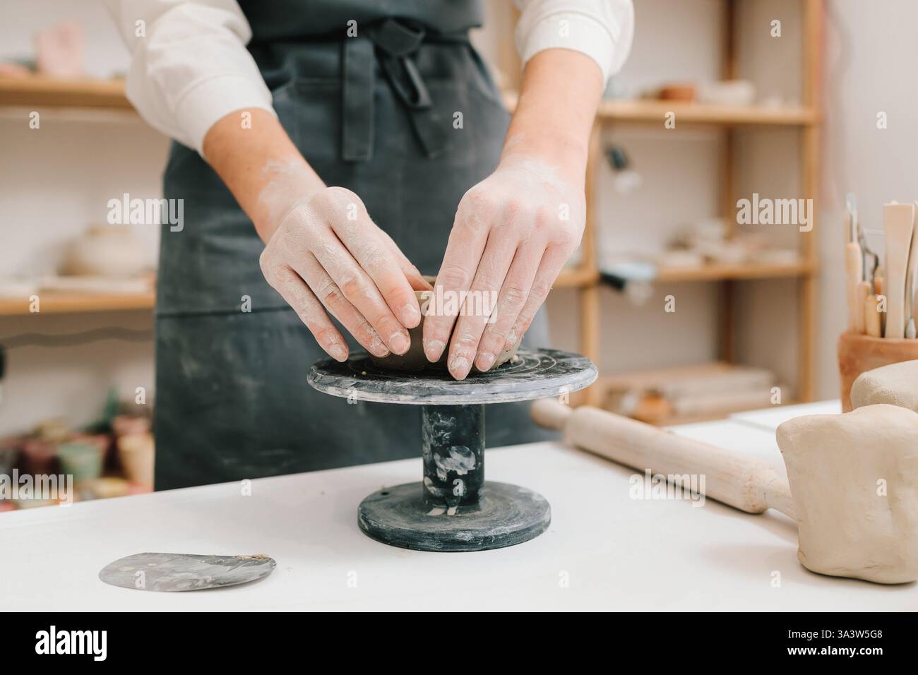Process of creating ceramic products. Female potter hands shows ceramic ...