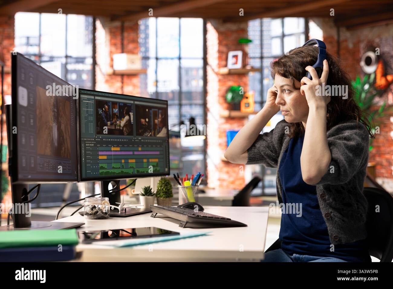 Woman filmmaker editing video footage with professional software, creating a montage for a ...