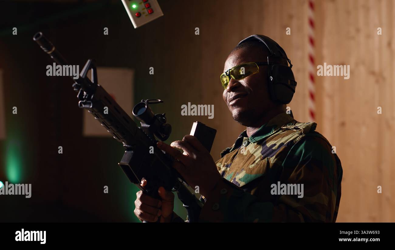 Portrait of cheerful soldier doing training in shooting range ...