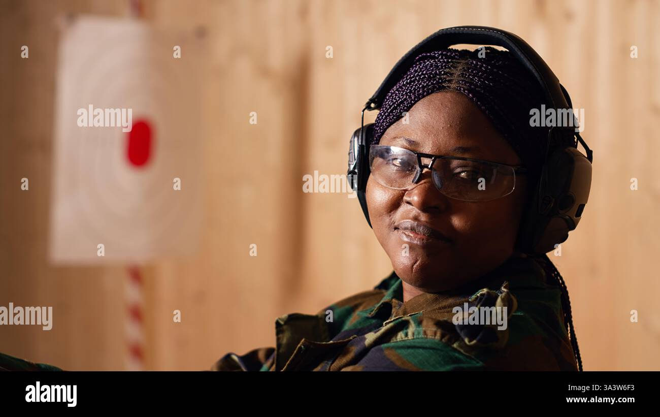 Smiling woman in firing range doing recreational shooting activity with ...