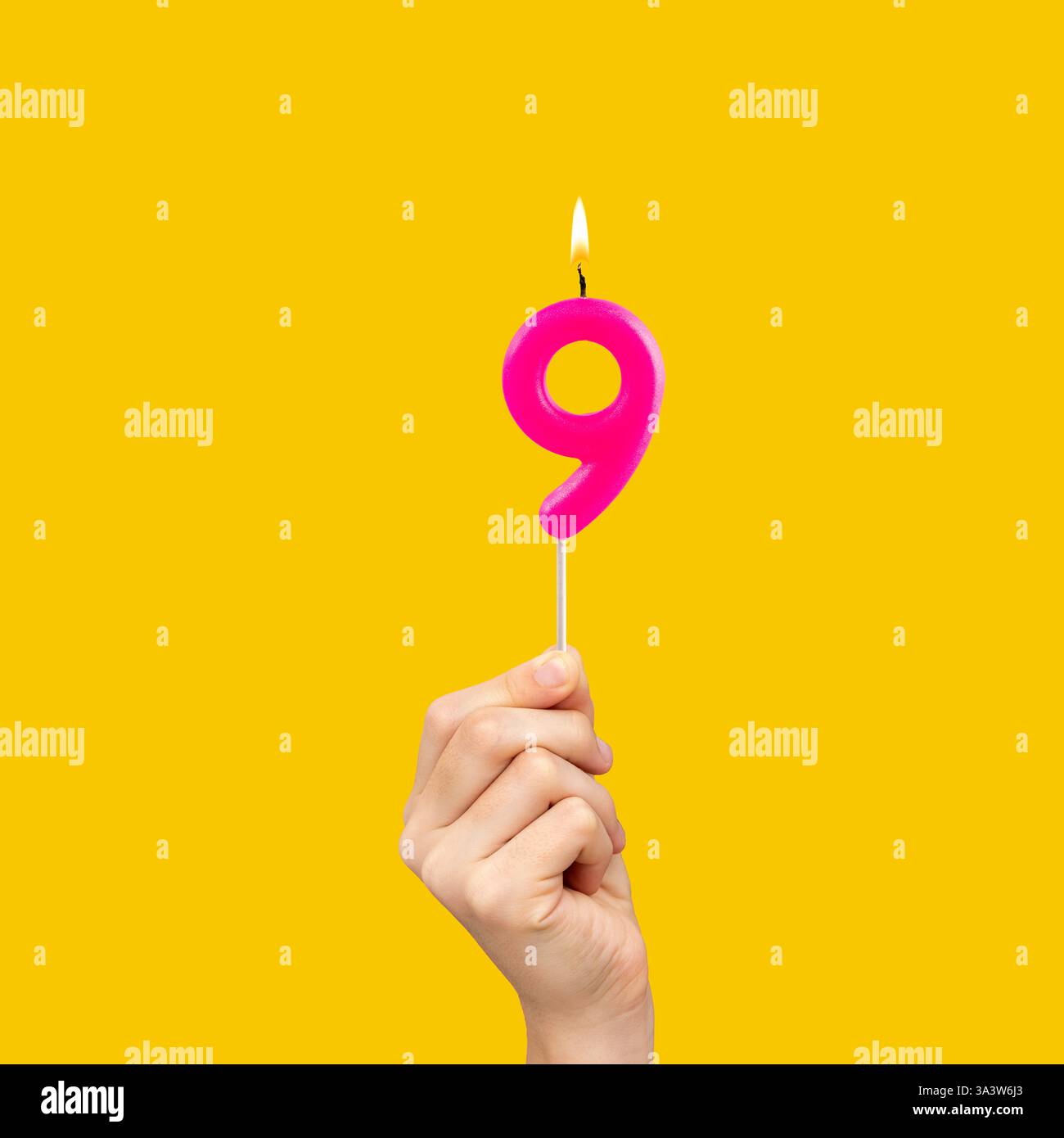 Birthday number 9 - Hand holding fuchsia colored candle Stock Photo - Alamy