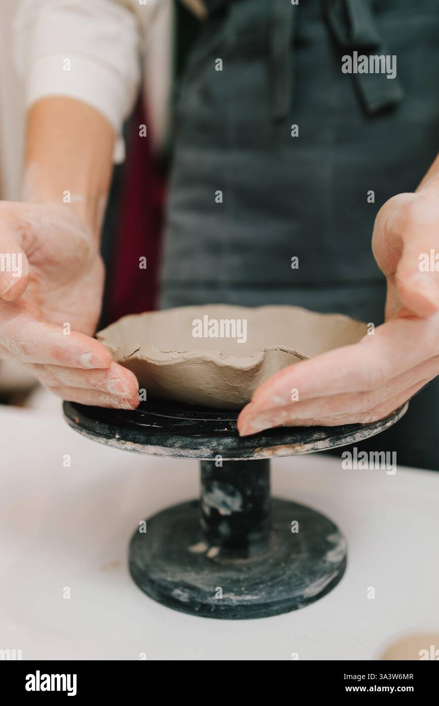 Artisan sculpts ceramic bowl using potter's wheel. Hands shaping clay ...