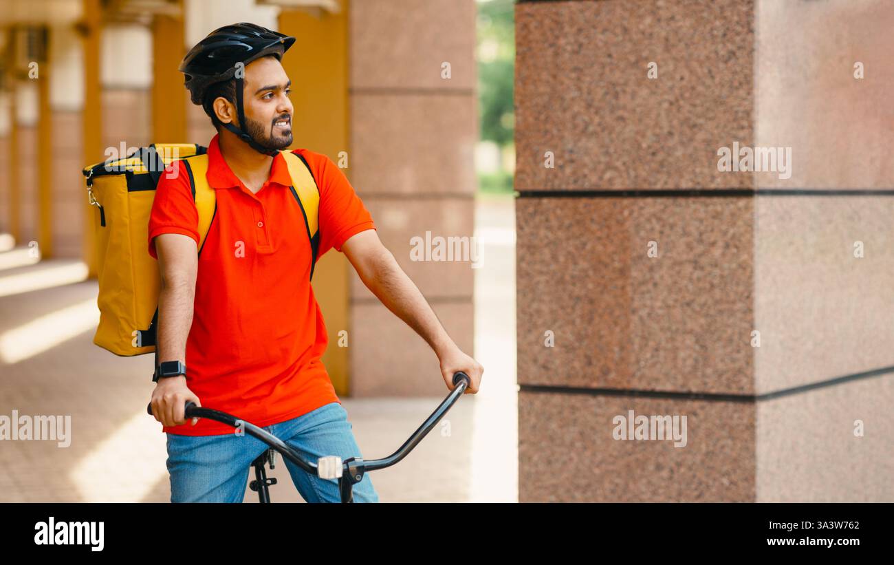 Active work outdoors. Smiling young man in helmet with yellow bag on ...
