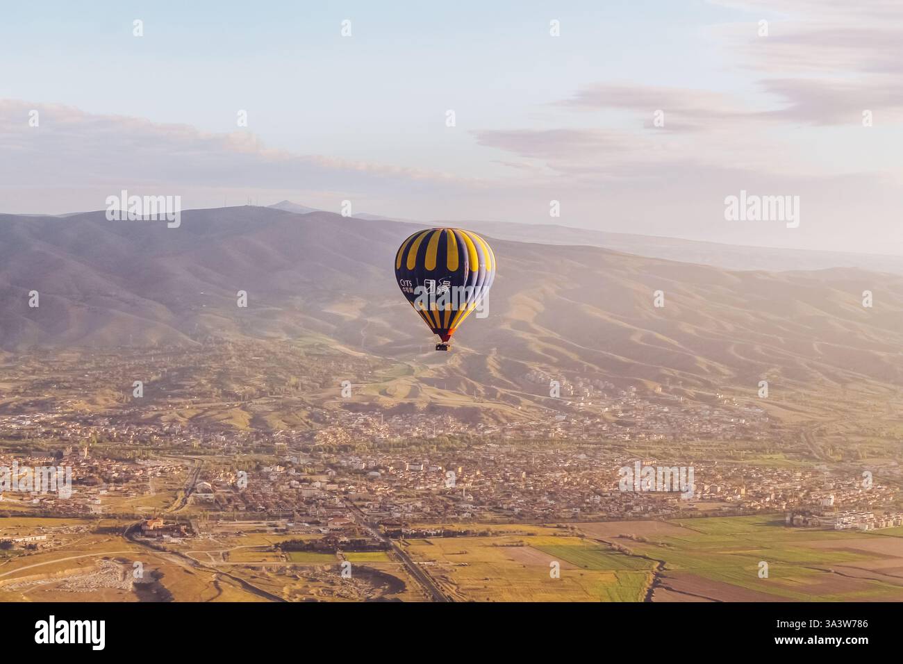 A single colorful hot-air balloon floating above the rocky landscapes ...