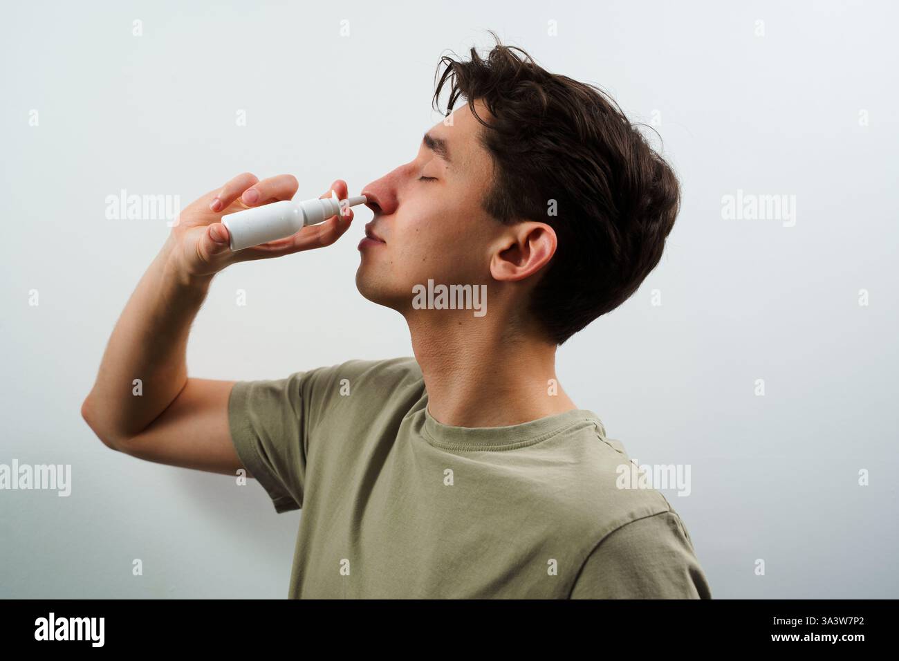 Patient is taking nose drops for sinusitis treatment on white ...