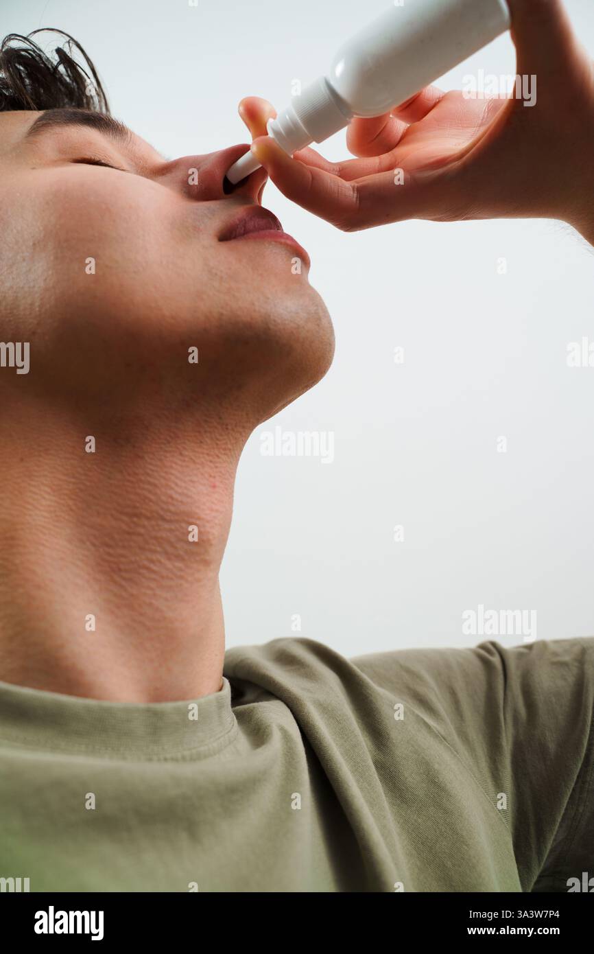 Patient is taking nose drops for sinusitis treatment on white ...