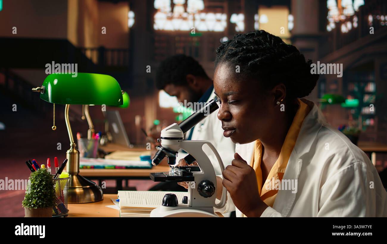 Female science student examines cells under the microscope for her ...